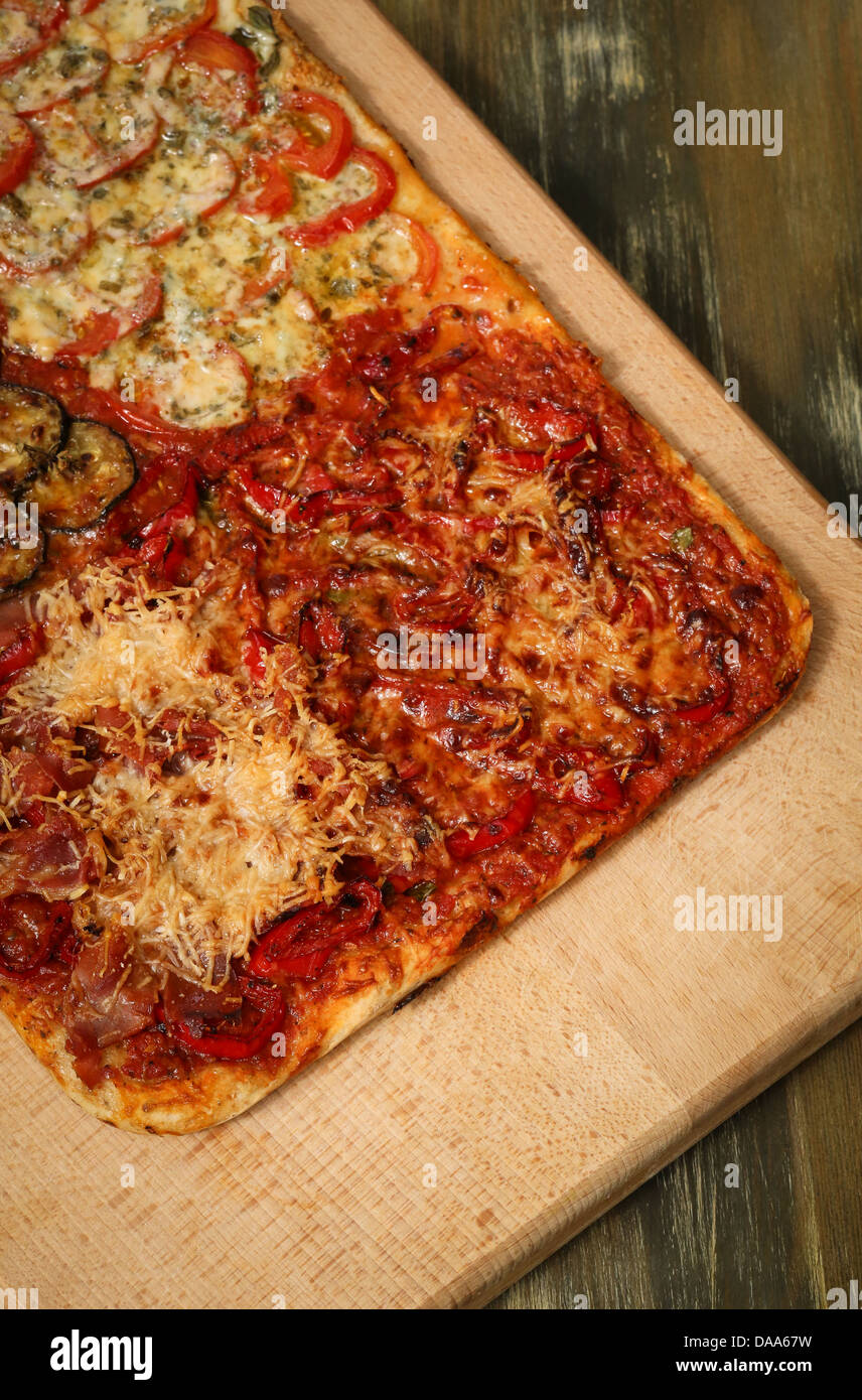 Square shaped homemade pizza four tastes on wooden board Stock Photo ...