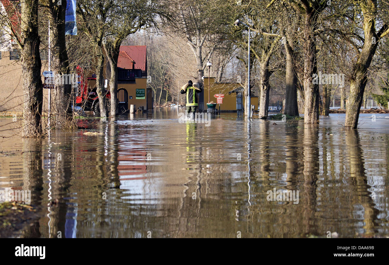 A firefighter carries sandbags through Weisse Elster river in Leipzig ...