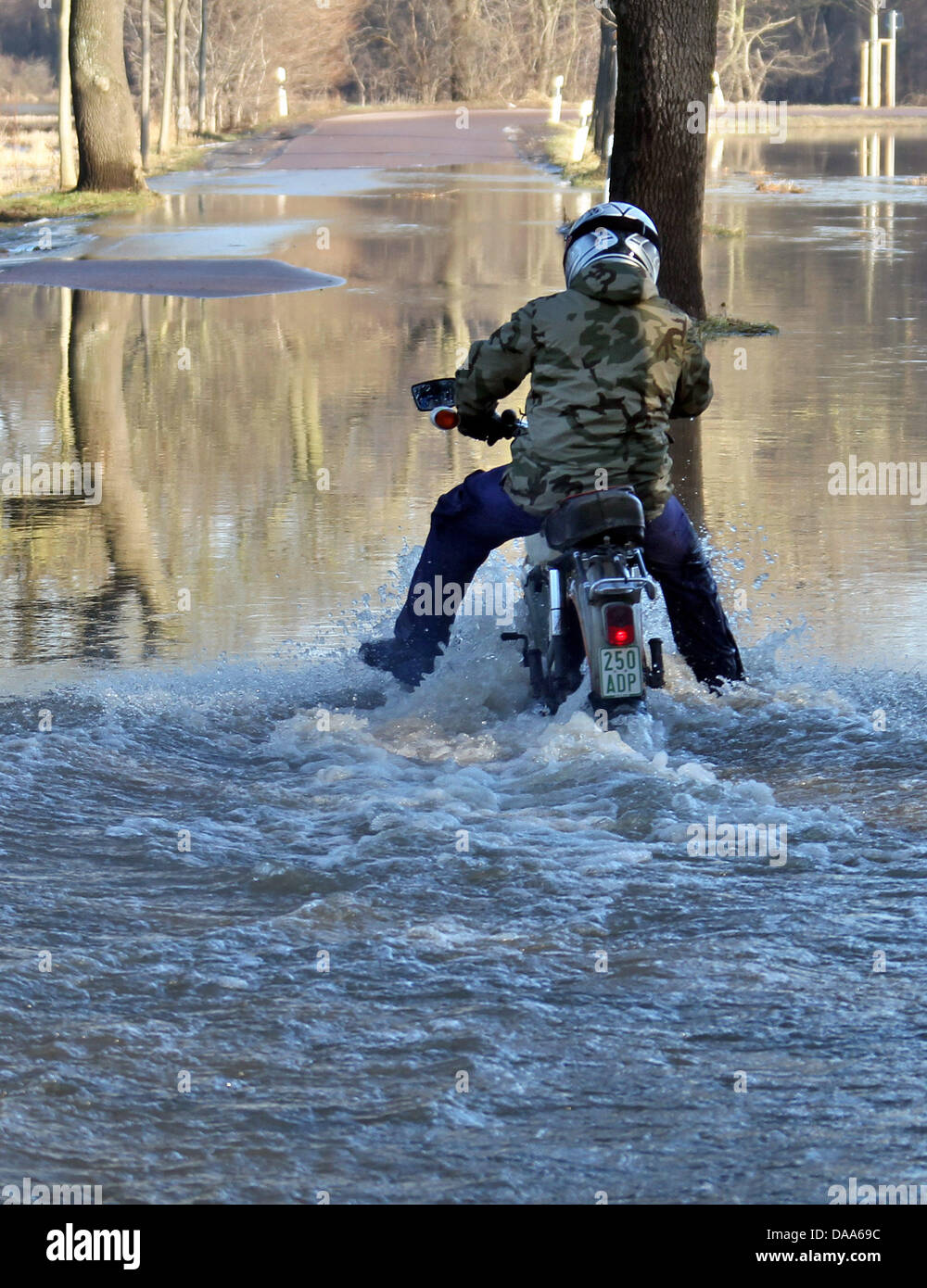 A man rides his scooter through Weisse Elster river in Leipzig, Germany ...