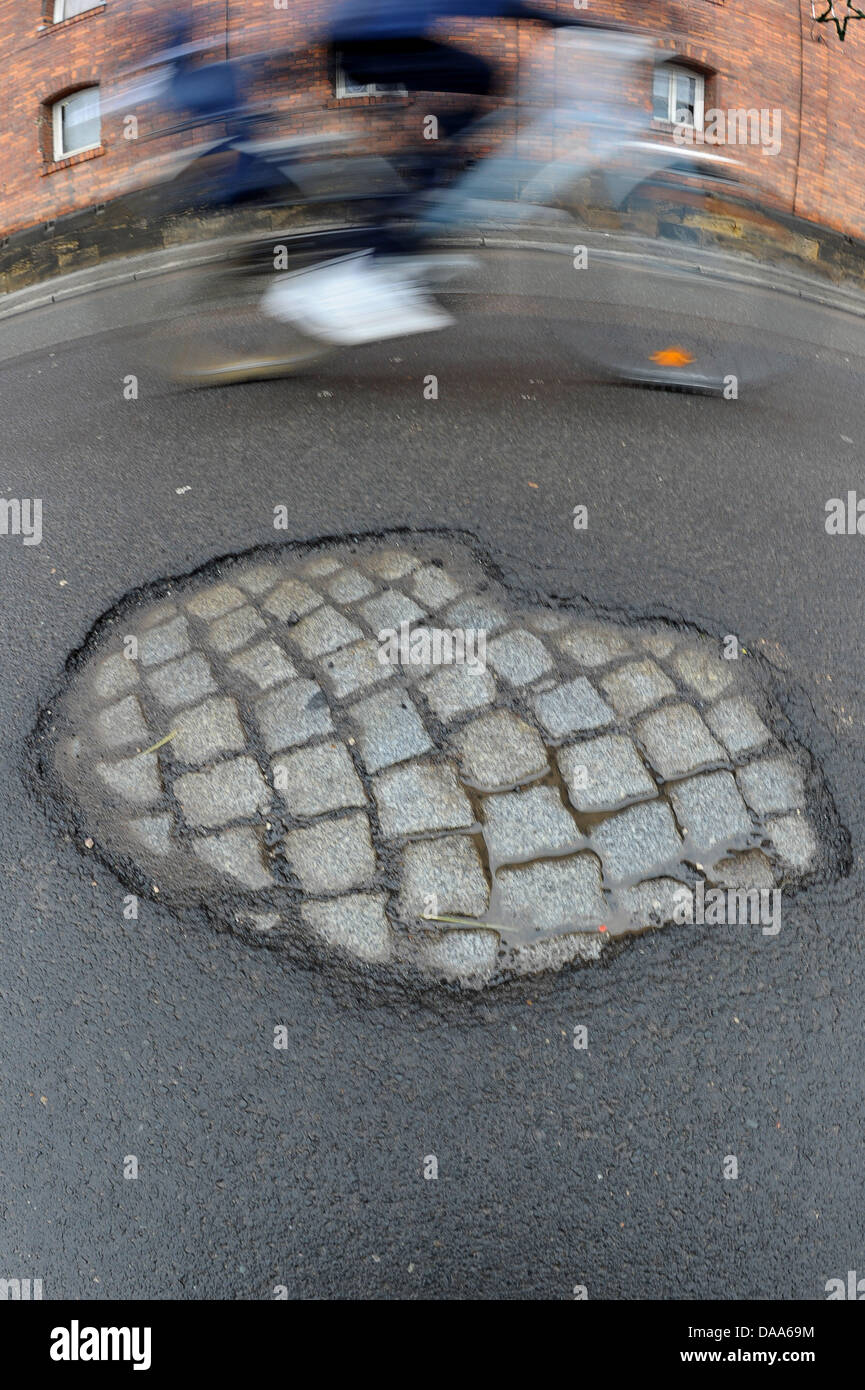 A cyclist avoids a pothole in Bamberg, Germany, 10 January 2011. The ...