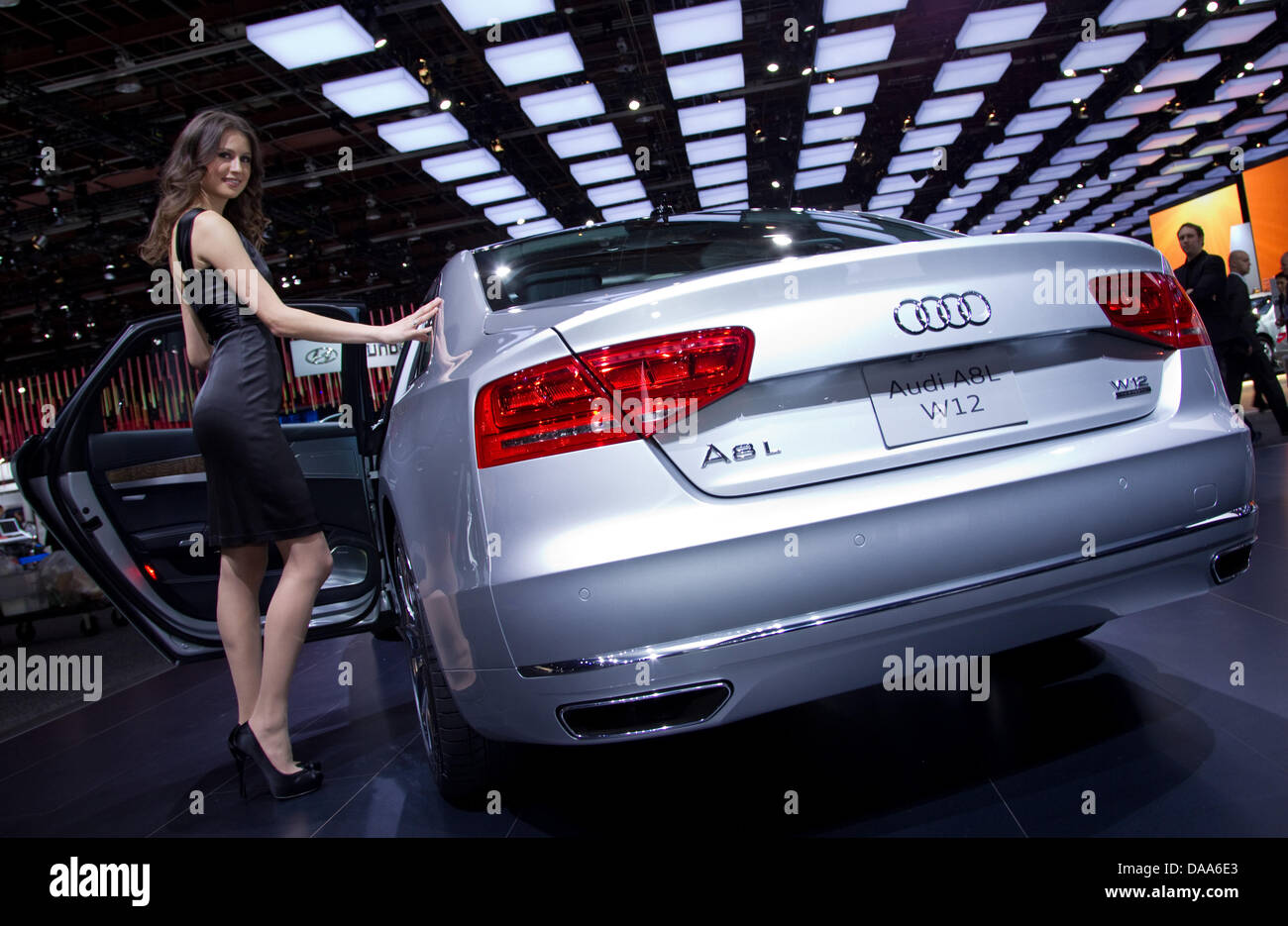 A woman smiles next to a Audi A8L W12 at the North American ...