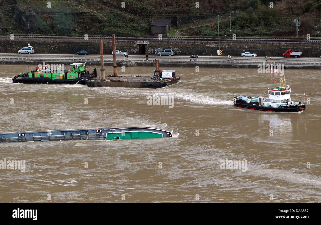 A tow-ship pulls a pontoon past the barge carrying acid capsized on ...