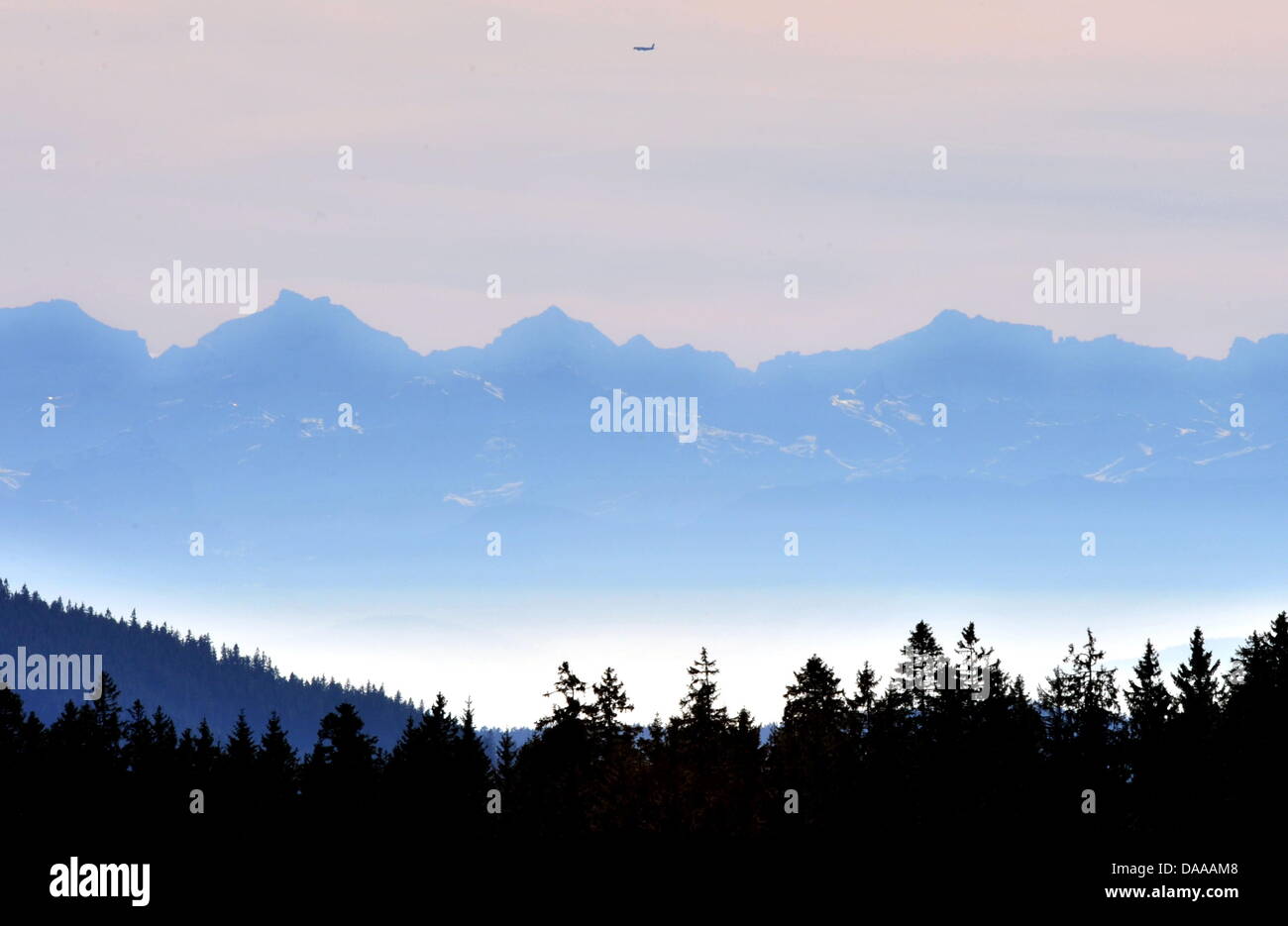 A plane flies over the Alps panorama as seen from the Feldberg in ...