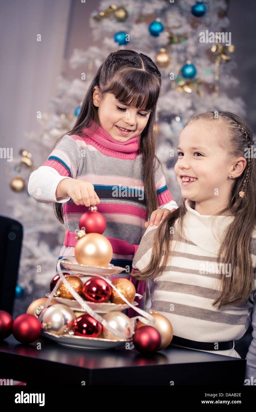two little girls getting Christmas Tree decoration Stock Photo - Alamy