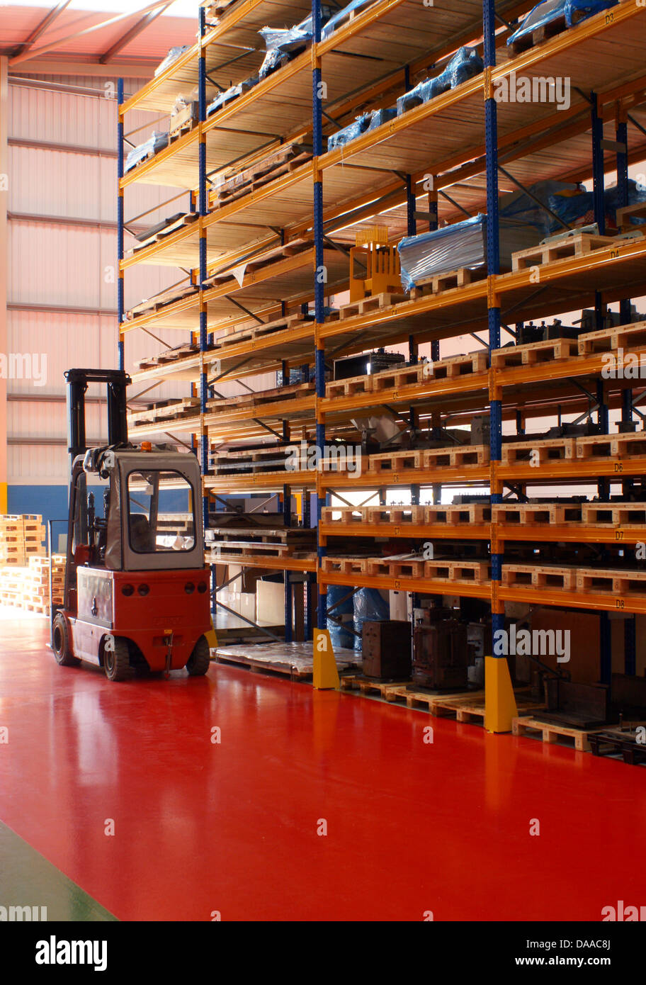 A a modern commercial warehouse with a fork lift truck and storage ...