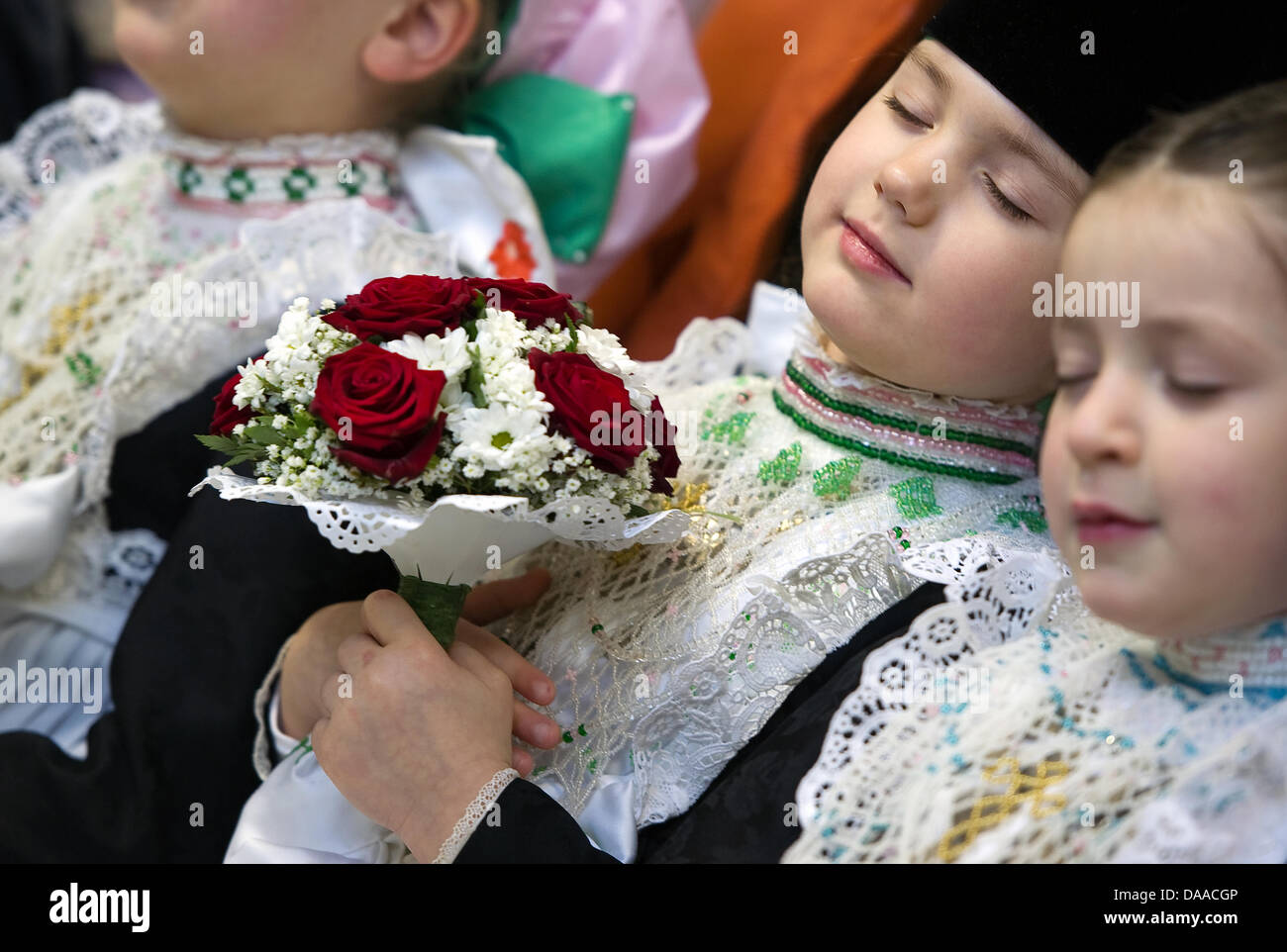 A little girl with traditional sorbian floral bouquet sits before the ...
