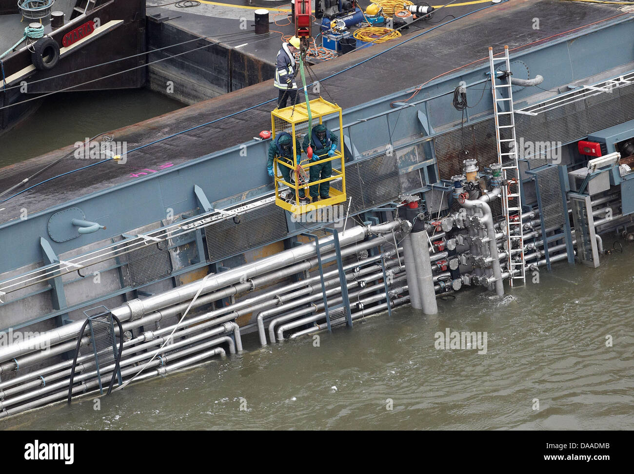 Rescue forces examine the ship's side of the capsized acid barge on ...