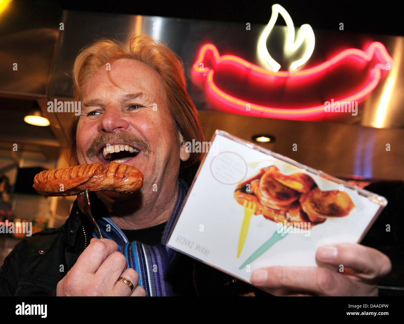 German singer Frank Zander poses with a currywurst and his new CD in ...