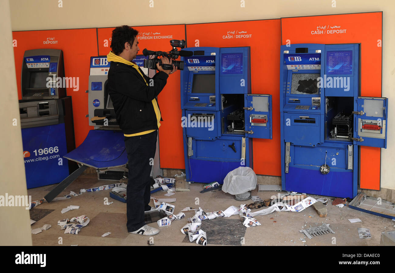 A journalist films a looted bank in Cairo, Egypt, 29 January 2011 ...