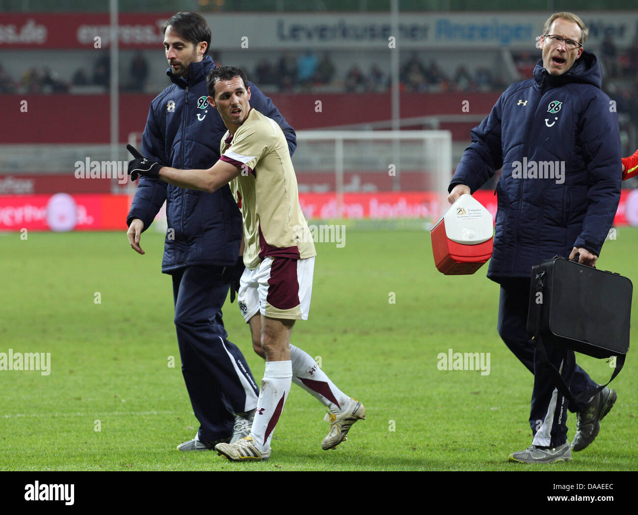 A team of medics walk Hanover's injured player Sergio Pinto (C) off the ...
