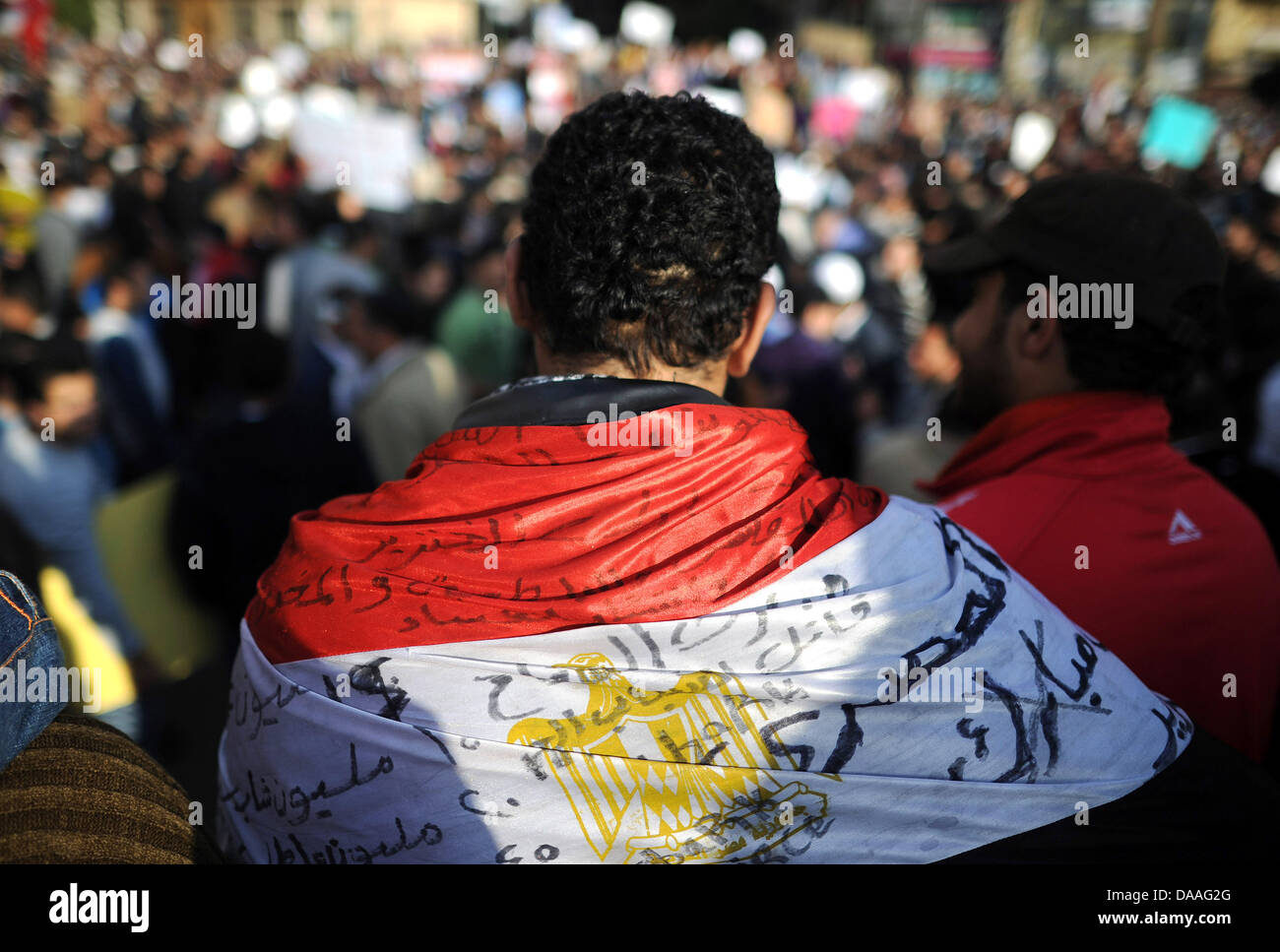 A demonstrator has wound the Egyptian flag around his shoulders at the ...
