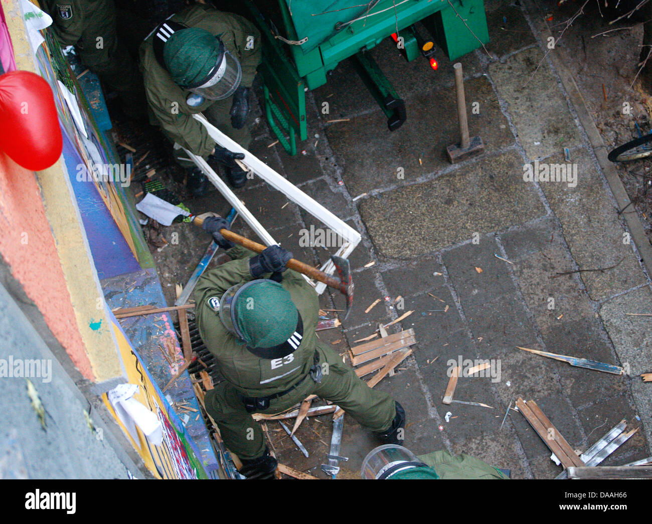 Polices officers break open the doors and windows of squatted house at ...