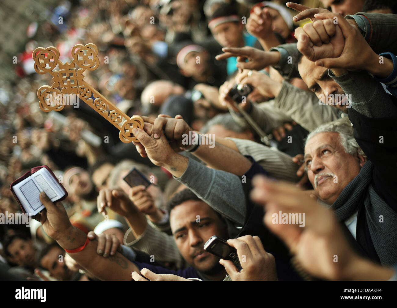 A coptic christian is praying between protesters in Tahrir square, in ...