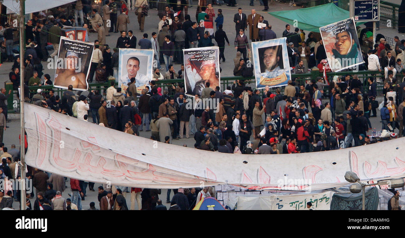 Opponents of the Mubarak regime hold up photos of missing or injured ...