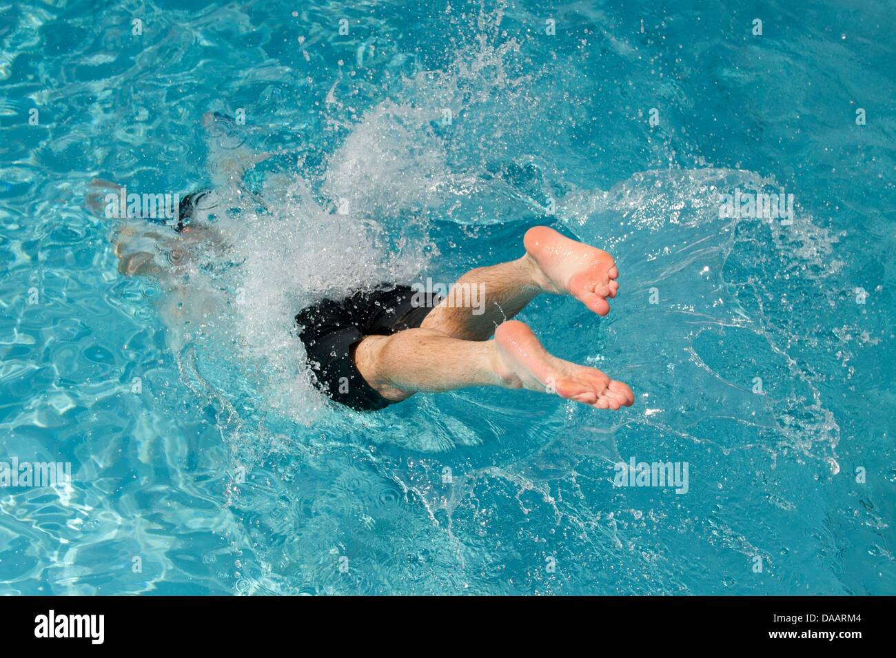 A swimmer jumps into the water at Georg-Arnold-Bad swimming pool in ...