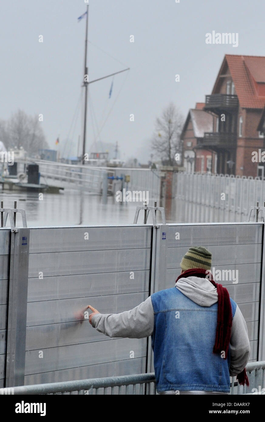 A man touches the new high water protection wall nearby the old city ...