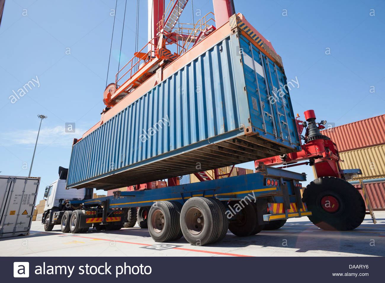Crane loading cargo container onto lorry at commercial dock Stock Photo ... Crane loading cargo container onto lorry at commercial dock Stock Photo ...