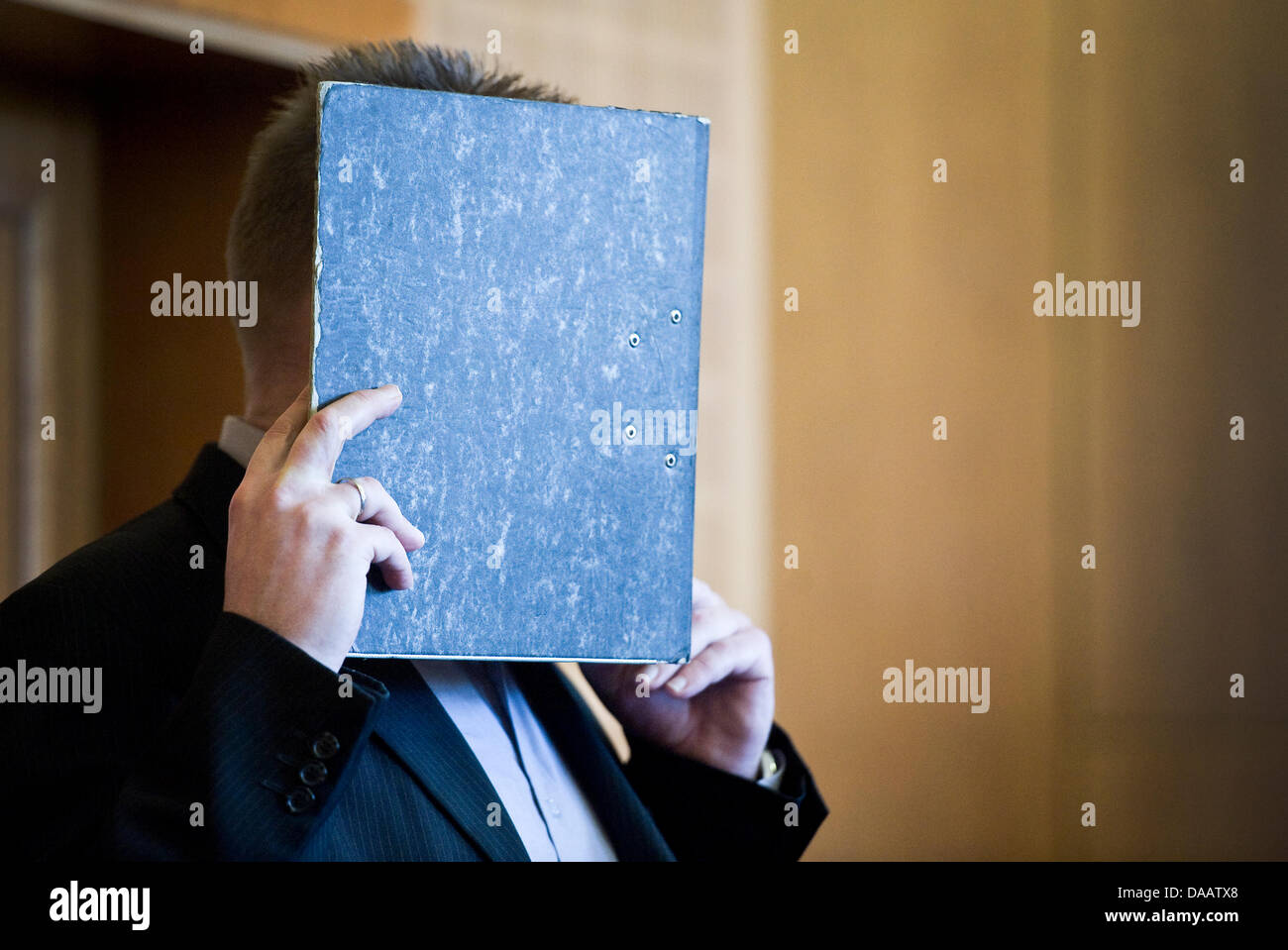 Defendant Olaf H covers his face with a folder in the courtroom at the ...