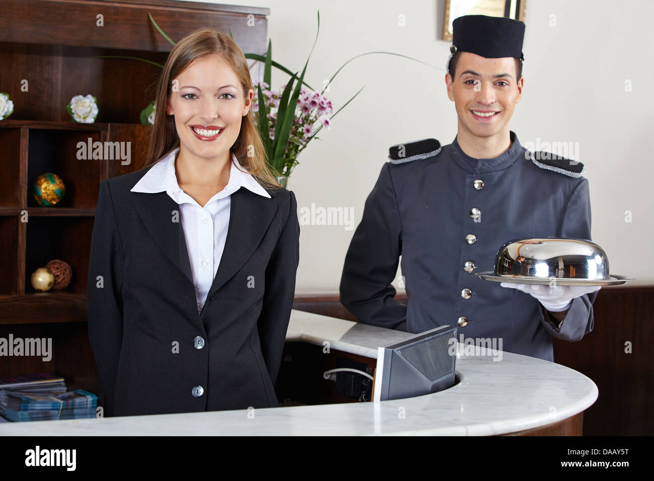 Happy concierge and receptionist in hotel waiting at counter Stock ...
