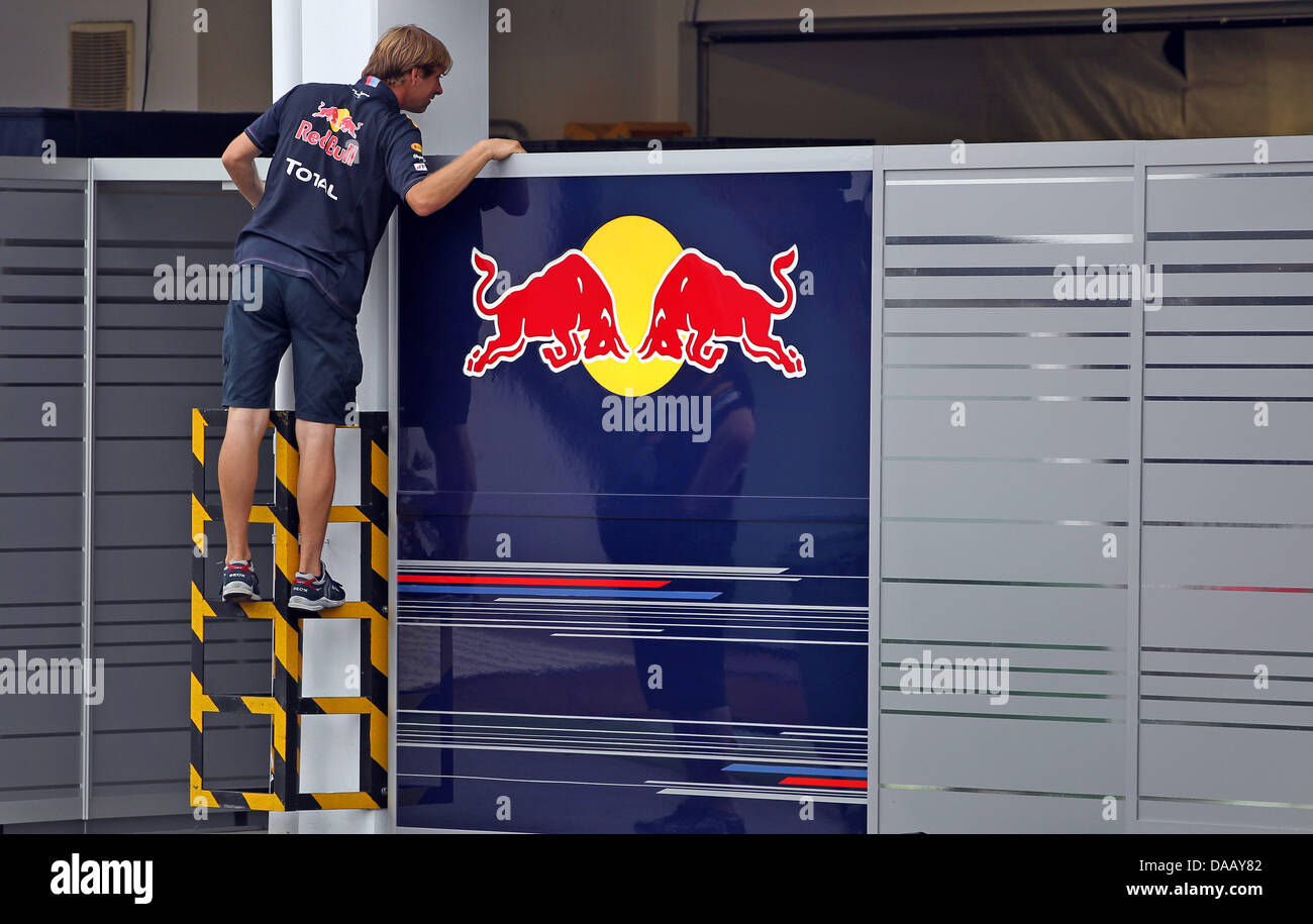 A Mechanic of Red Bull peeps into the team garage at the race track ...