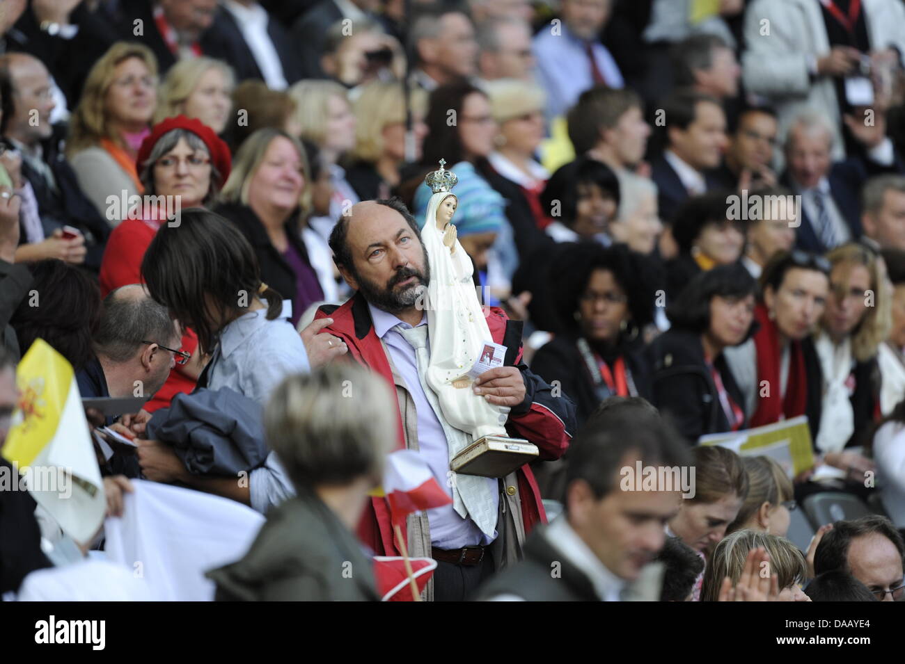 A believer with a statue of Maria is waiting at the Olympic Stadium in ...