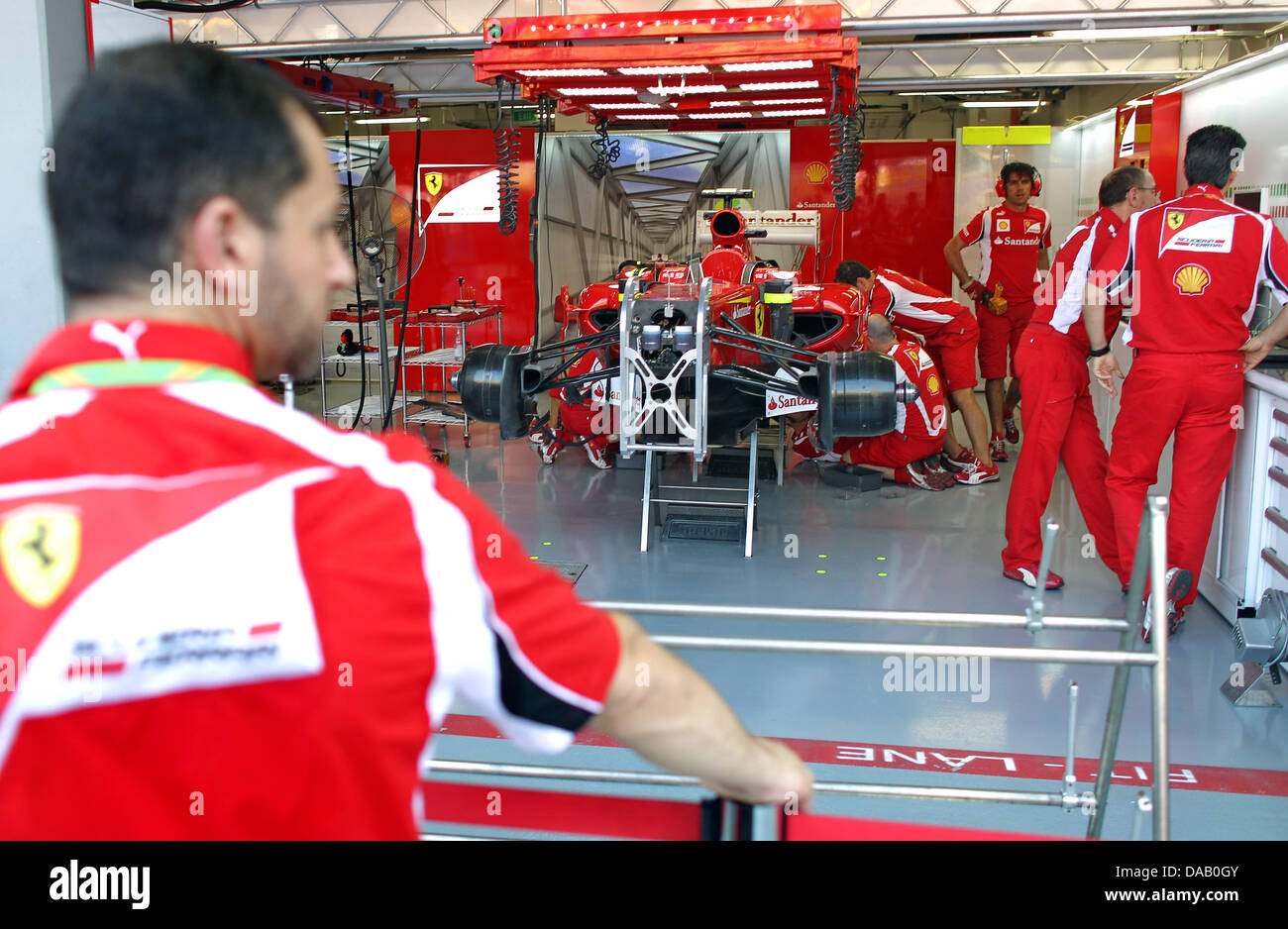 Mechanics of Ferrari working in the teams garage at the race track ...