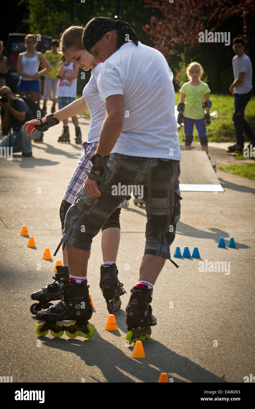 Couple synchronously roller blading through slalom cones Stock Photo ...