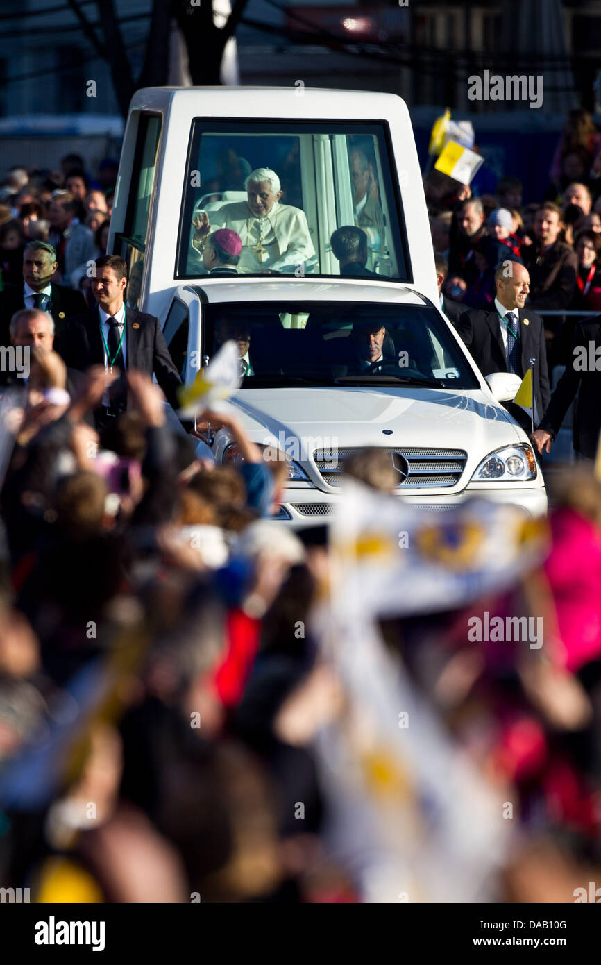 Pope Benedict XVI drives trough the faithful with his Papamobil before ...