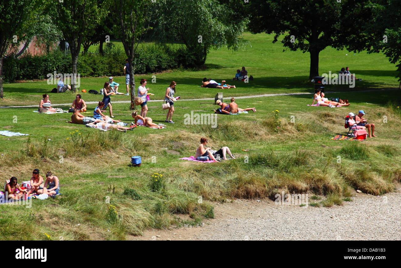 People sunbathing in Ilkley, West Yorkshire near the River Wharfe Stock ...