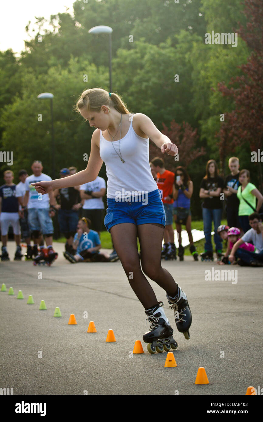 Teenage girl roller blading through slalom cones Stock Photo - Alamy