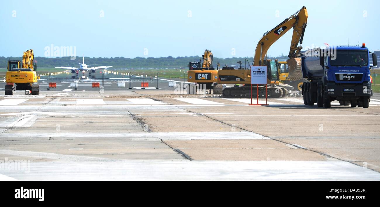 Construction machines rip up the old concrete surface of runway 5 as ...