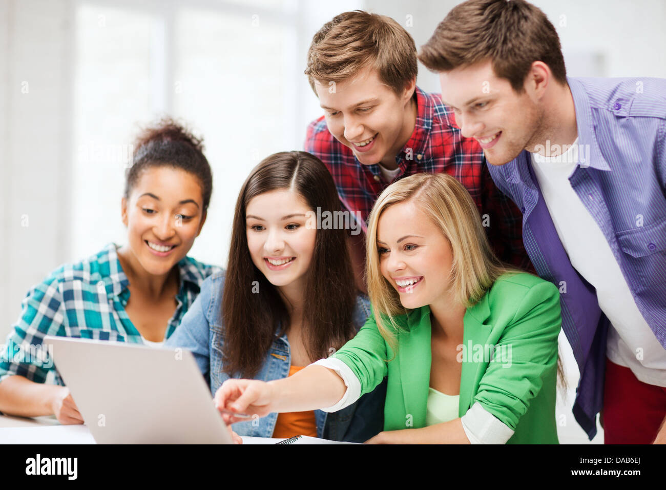 smiling students looking at laptop at school Stock Photo - Alamy