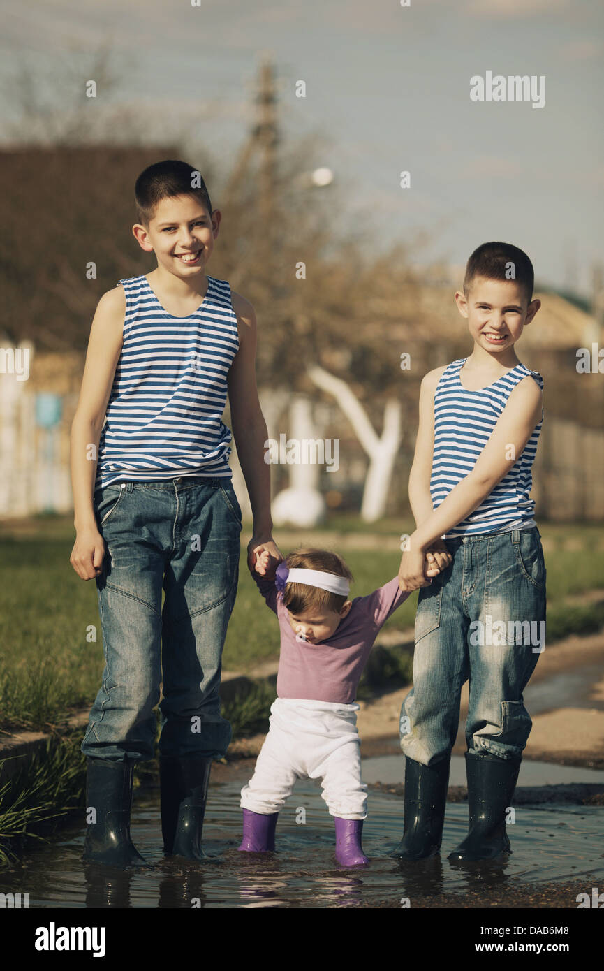 little happy children playing in the puddle Stock Photo - Alamy