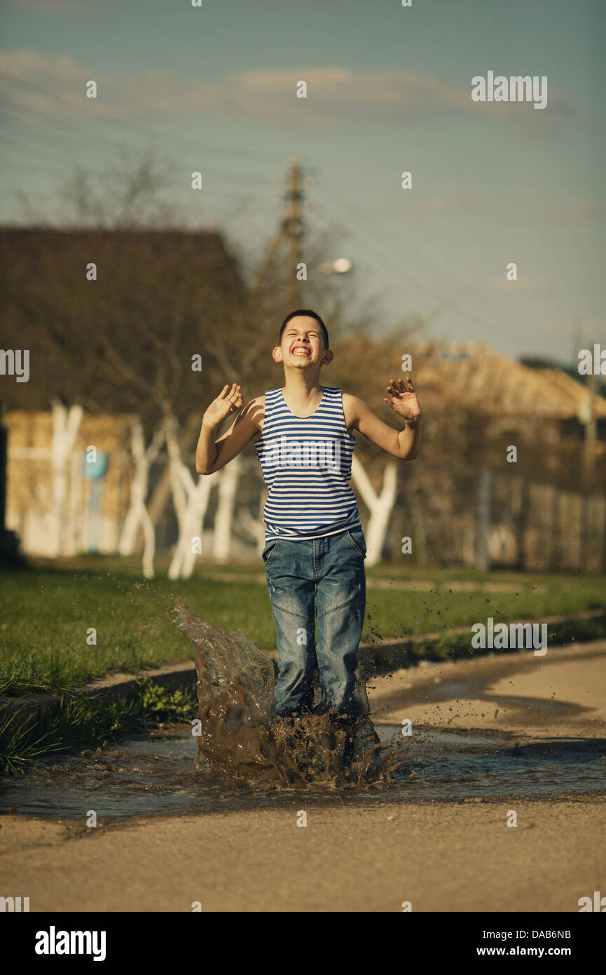 little happy boy standing in puddle Stock Photo - Alamy