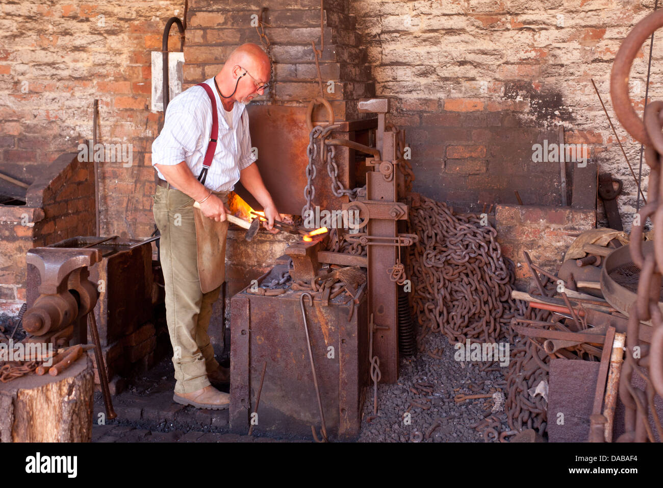 Blacksmith making chain in an old furnace and workshop in the Black ...