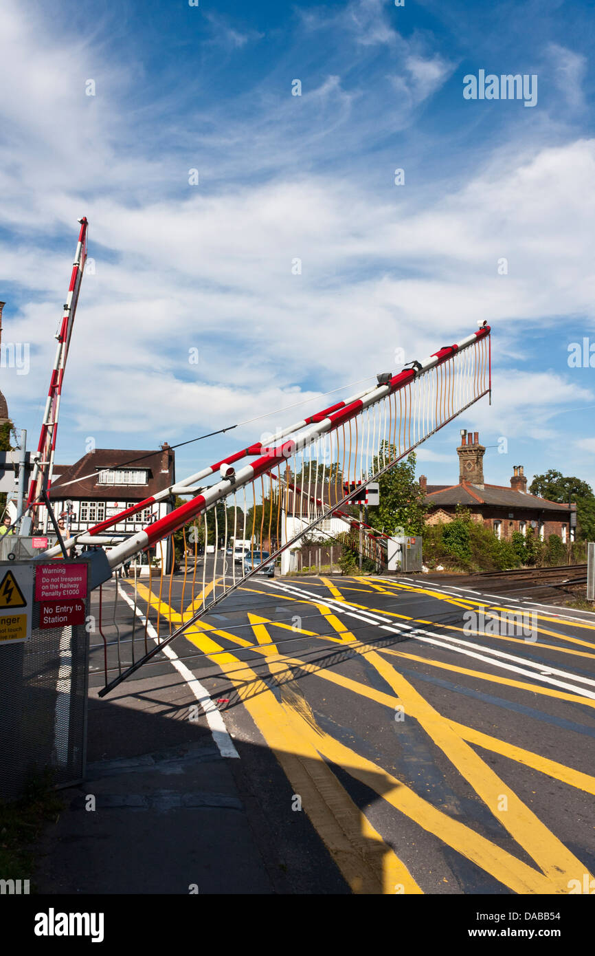 Barriers fall at an English level crossing as a train approaches in the ...