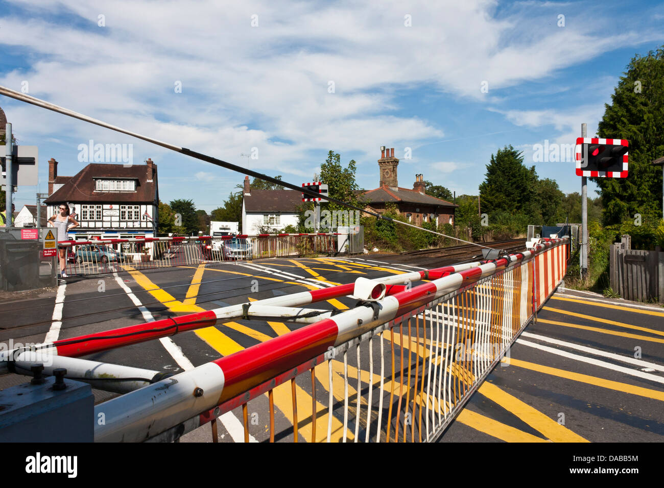 Barriers are down at an English level crossing as a train passes in the ...