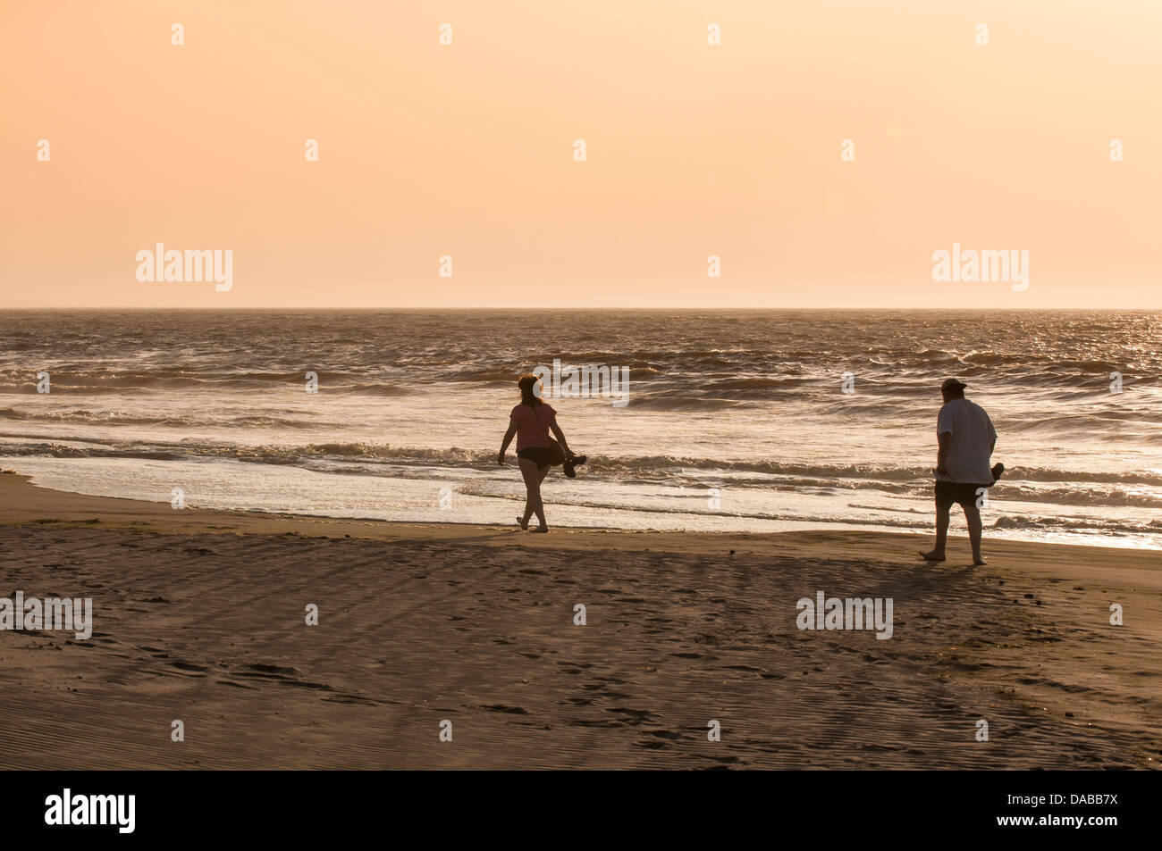 Couple taking a romantic walk on Vichayito beach at sunset, Mancora ...