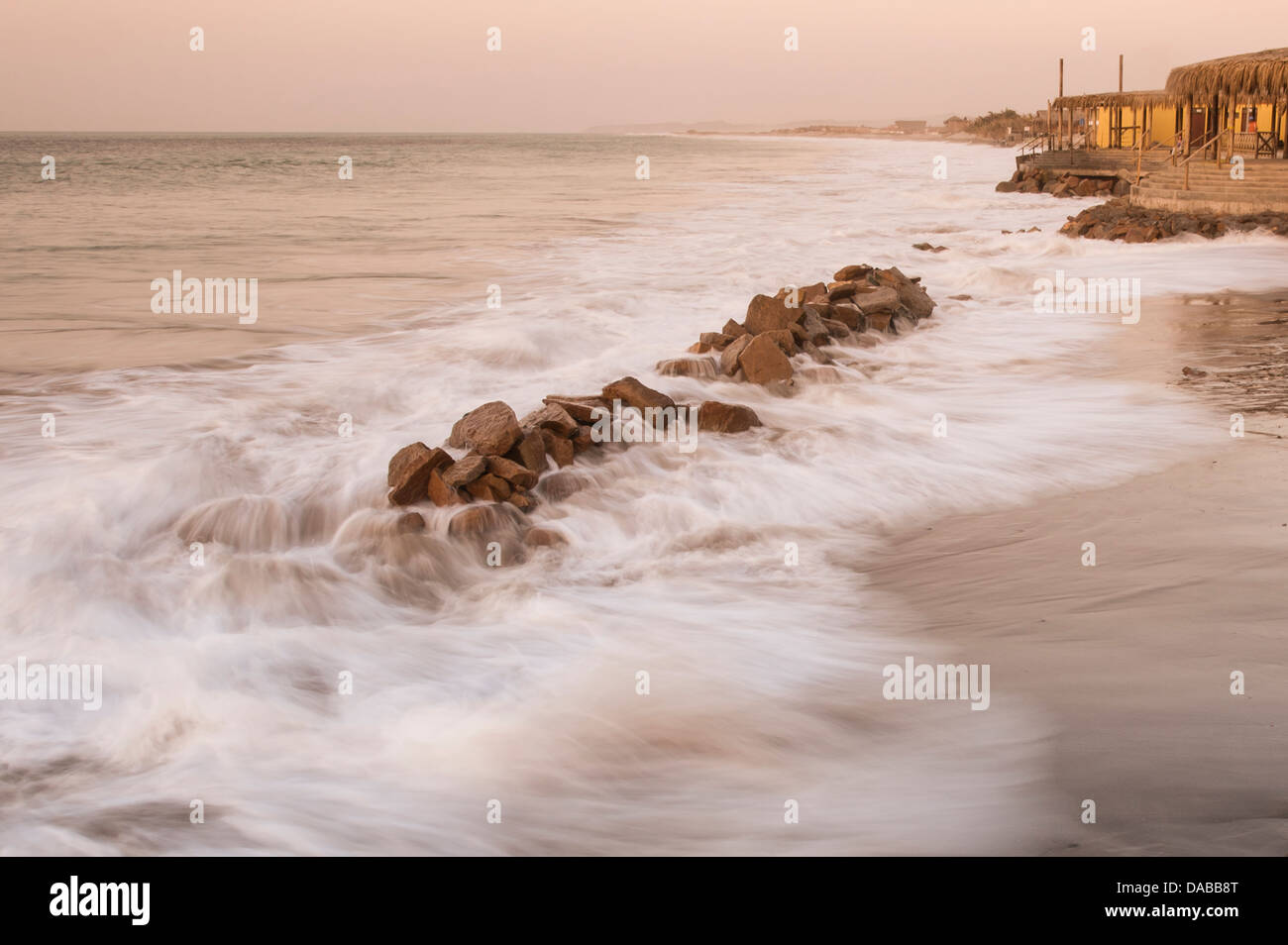 Surf on rocks at sunset on the beach in Mancora, Peru Stock Photo - Alamy
