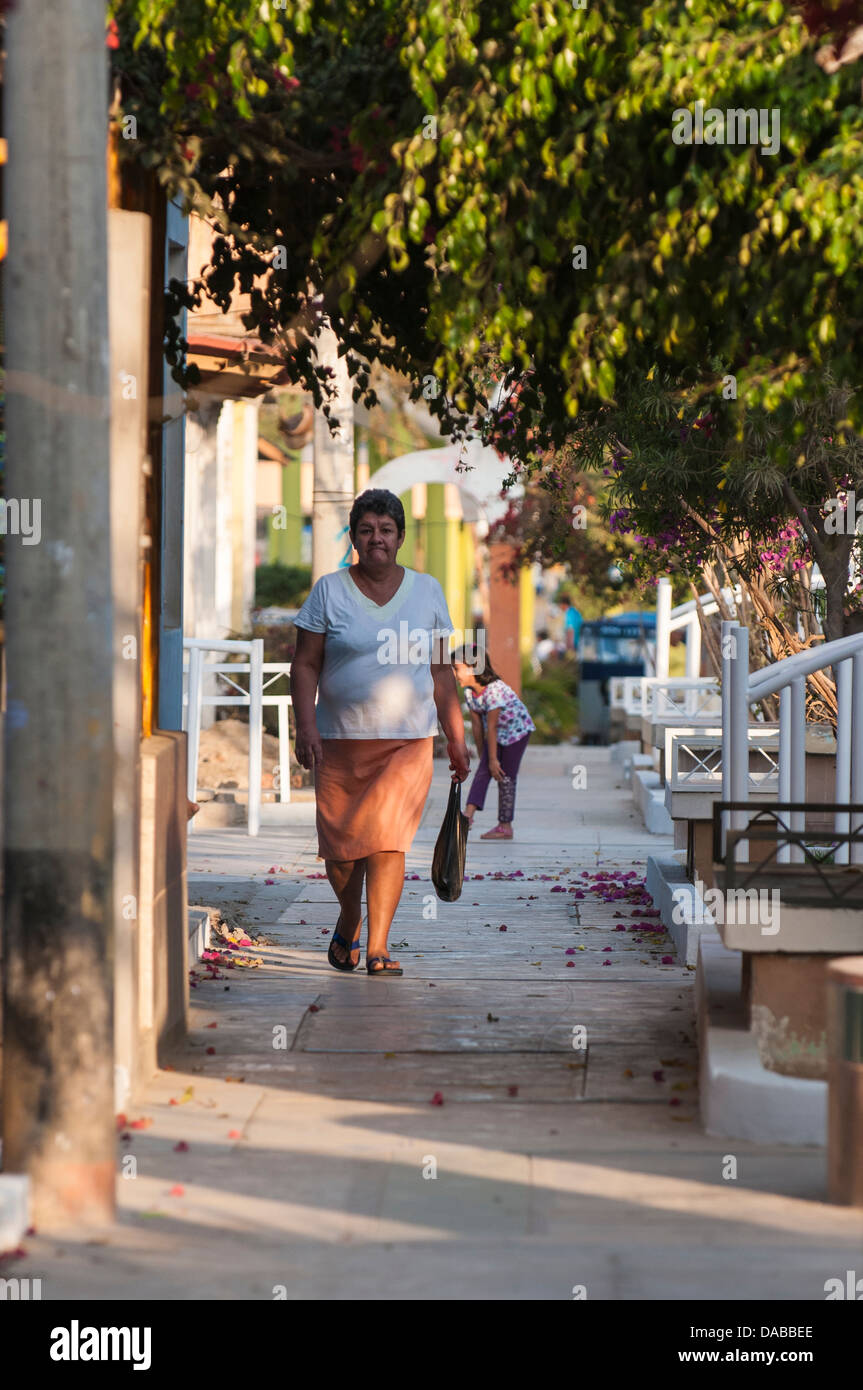 Woman walking on downtown street scene of Mancora, Peru Stock Photo - Alamy