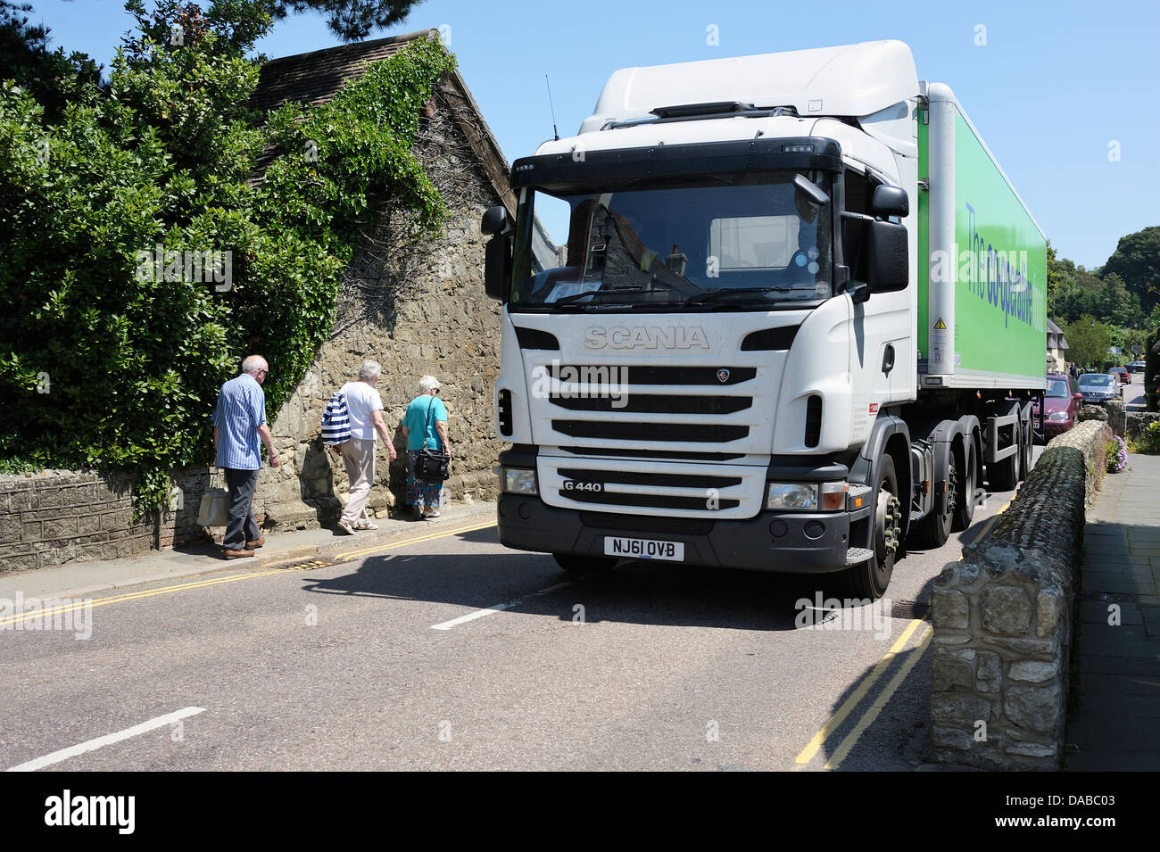 A huge lorry traveling through the narrow high street of the ...
