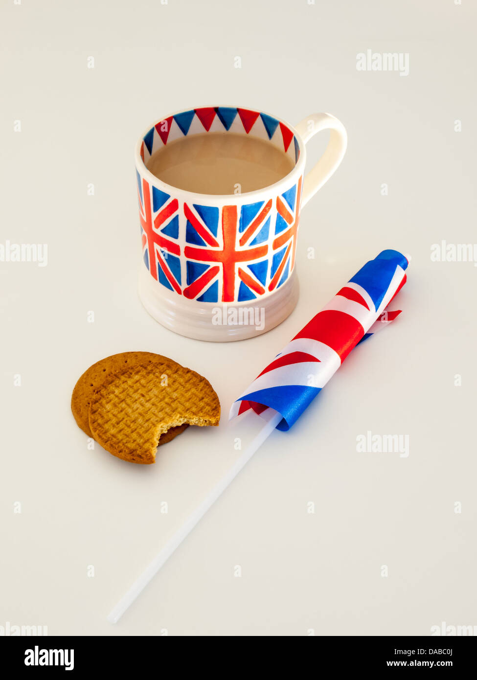 A cup of milky english tea in a british union jack mug with digestive ...