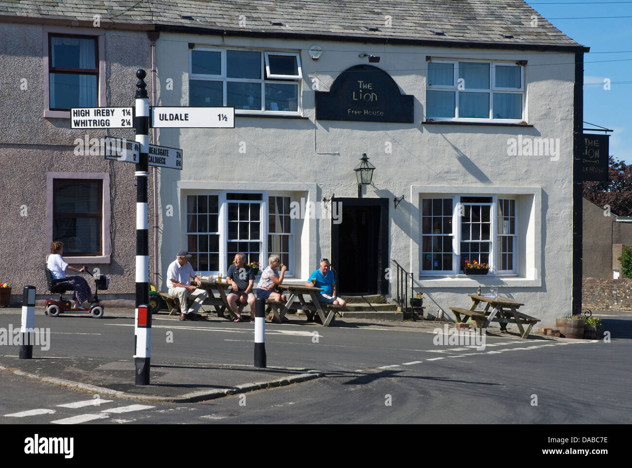 Drinkers outside the Lion pub in the village of Ireby, Lake District ...