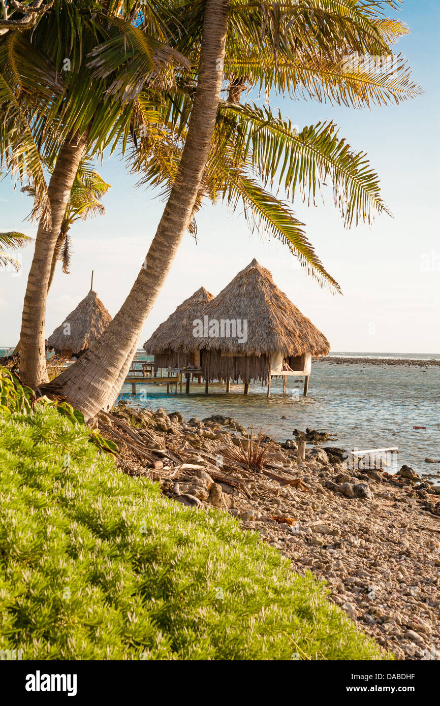 Thatched chalets on stilts over a coral lagoon on Glover's Reef in ...