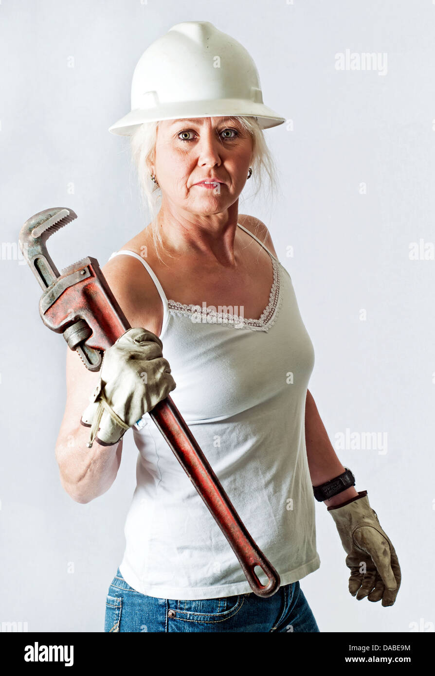 Strong woman worker holding a pipe wrench Stock Photo - Alamy