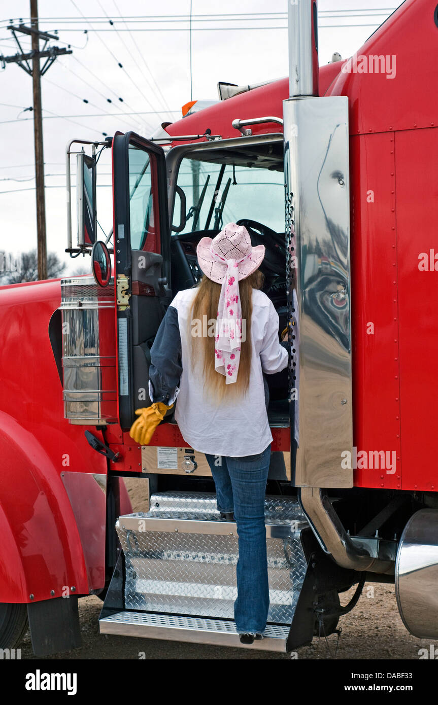 A woman truck driver enters the cab of a big rig Stock Photo - Alamy