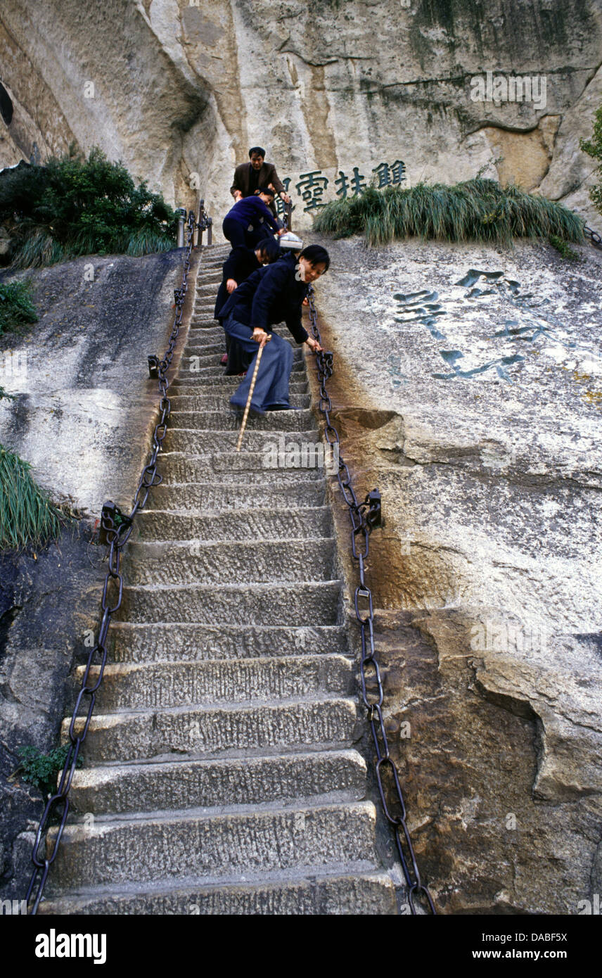 Chinese pilgrims and hikers descending rock cut stairs in Hua Shan ...