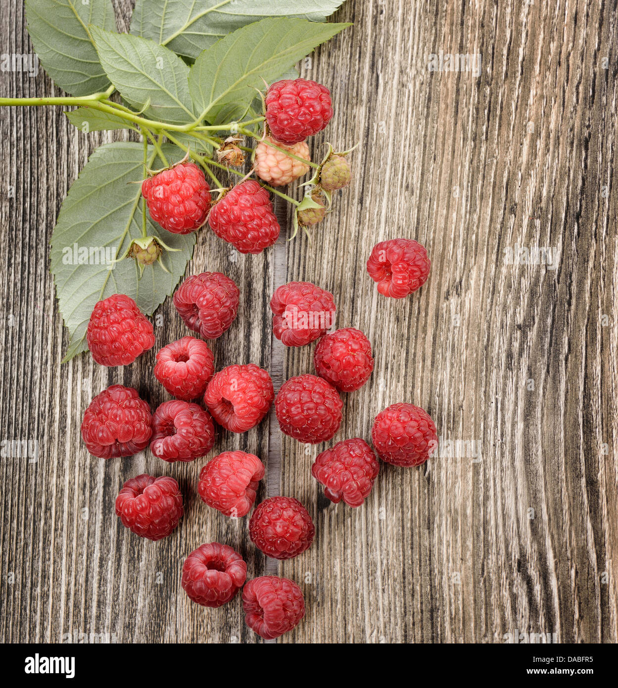 Raspberries With Leaves On The Rusty Wooden Table Stock Photo - Alamy