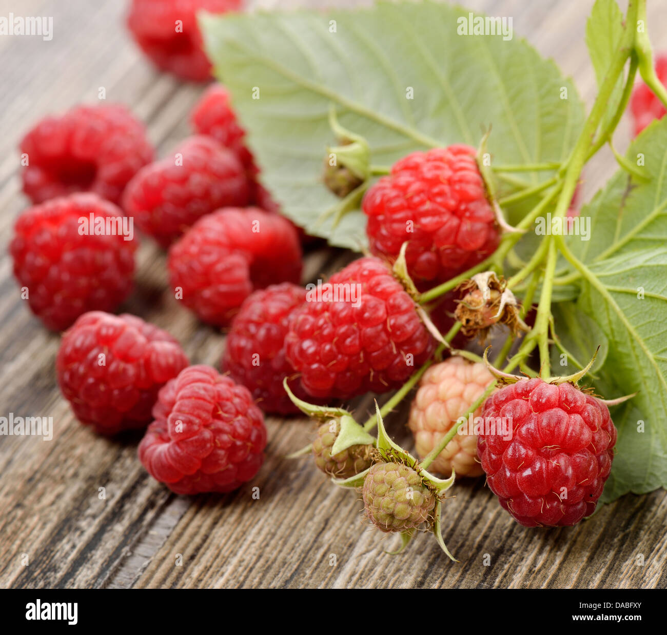 Raspberries With Leaves On The Rusty Wooden Table Stock Photo - Alamy