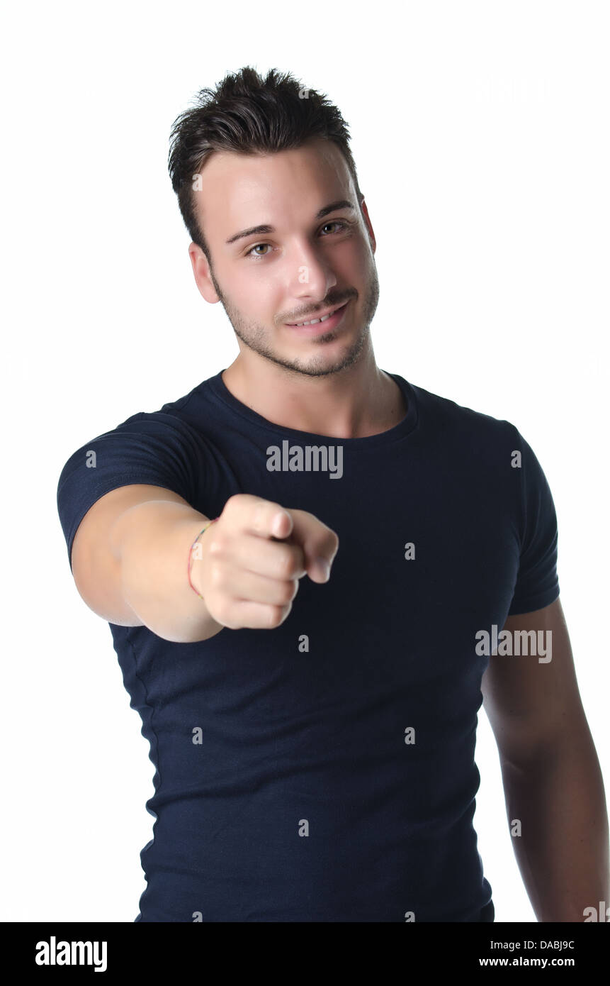 Smiling young man gesturing with his hand, pointing finger at you ...